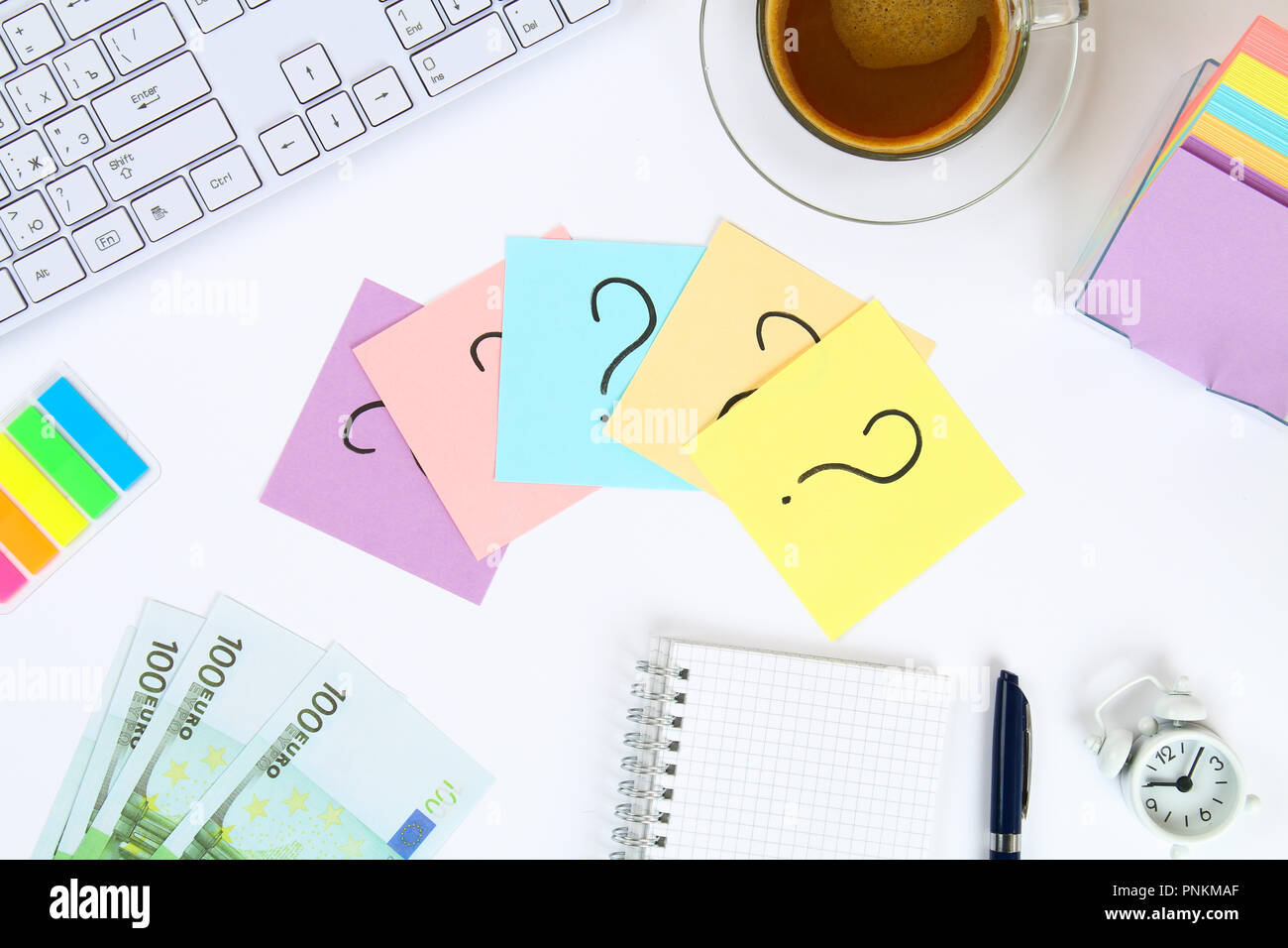 Multicolored stickers note with question mark on white desktop next to ...
