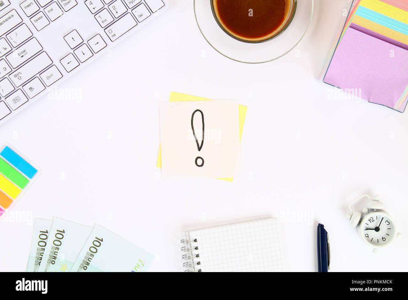 An exclamation point on the sticker is a note on a white desktop next ...