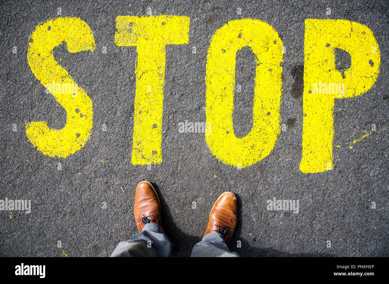 stop sign on the ground in front of feets Stock Photo - Alamy