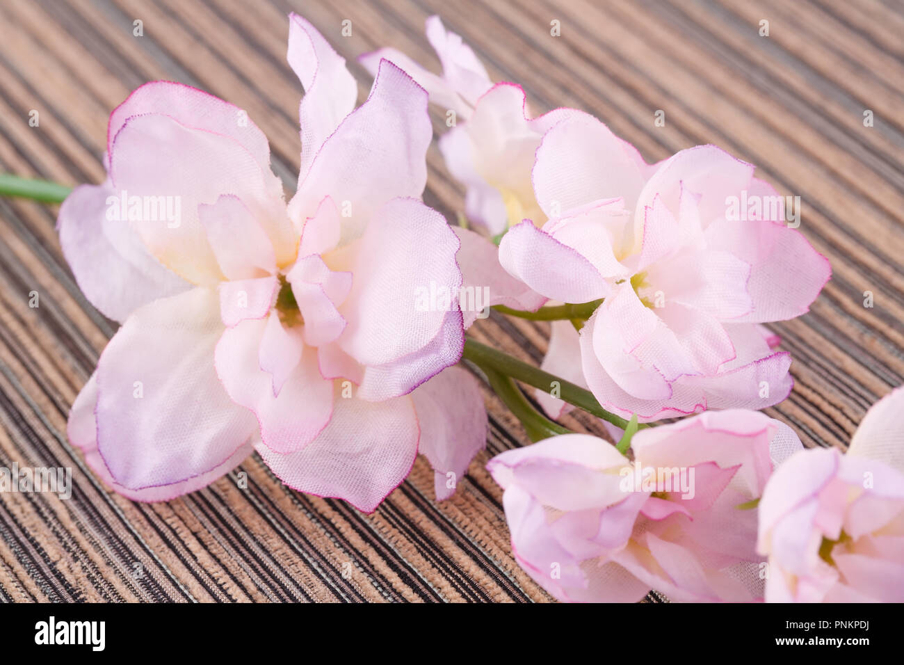 Pink artificial flowers on cloth background, closeup picture Stock ...