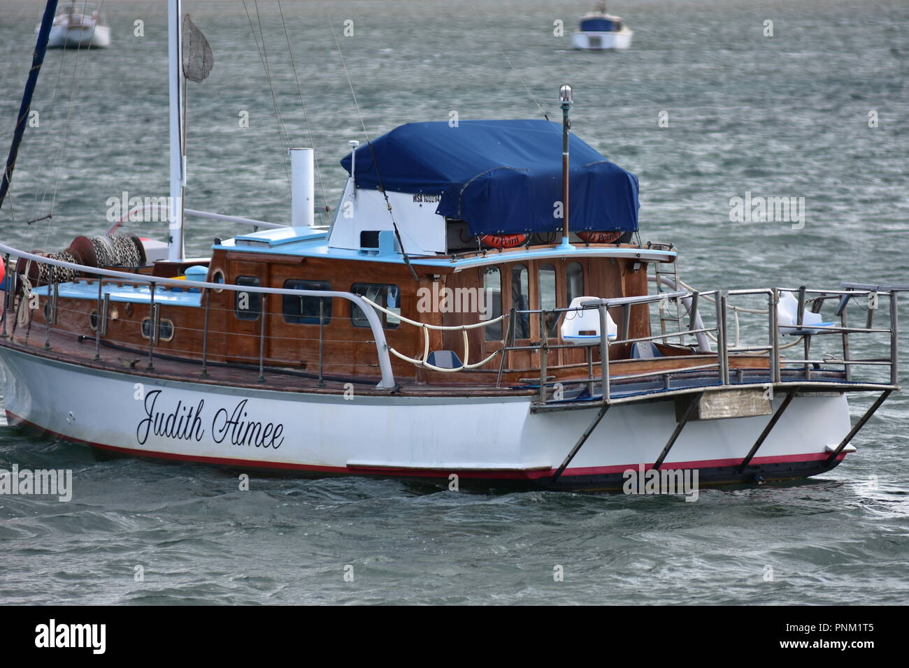 Classic motorsailor with decks and cabin in wood color moored on gray ...
