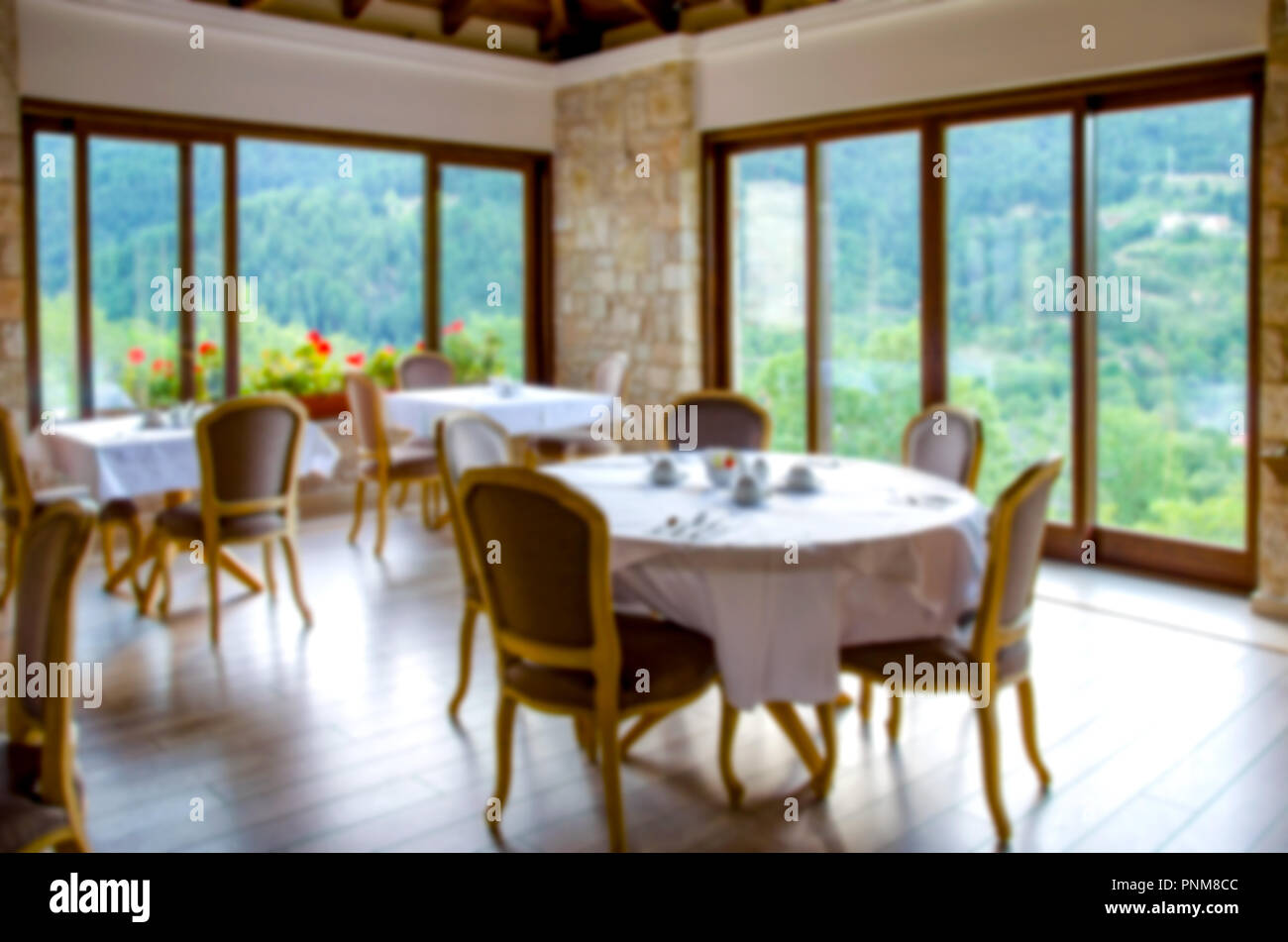 Interior of restaurant with wooden furniture ,stone walls and windows ...