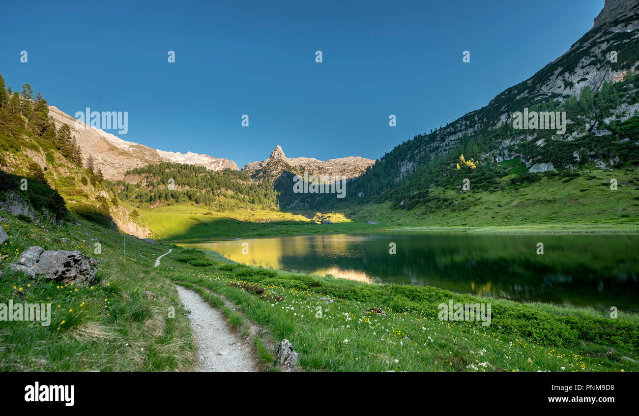 Path around the lake Funtensee, Schottmalhorn reflected in the ...