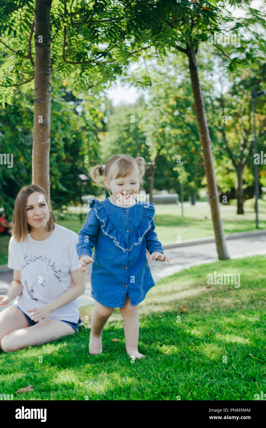 Portrait of 3 years old girl running away from her mother while playing ...