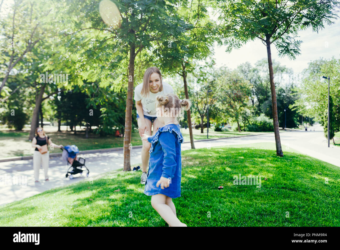 Portrait of 3 years old girl running away from her mother while playing ...