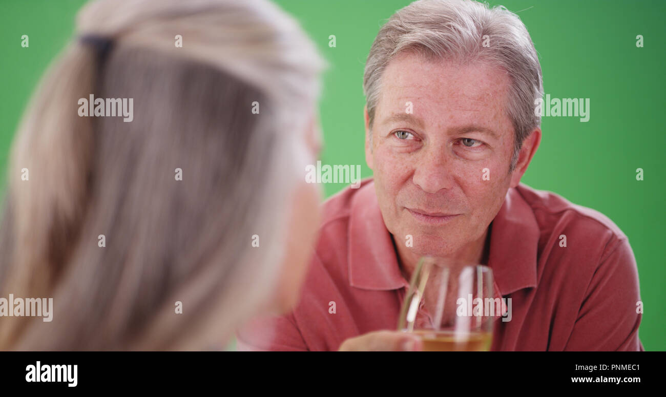 Mature middle aged male drinking wine with his female friend on ...
