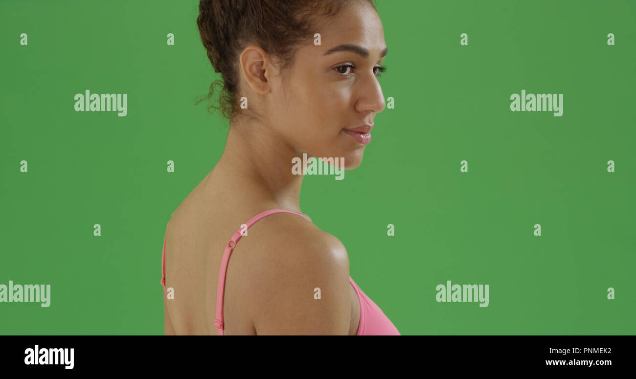 Young african American girl in sports bra looking offscreen on green ...