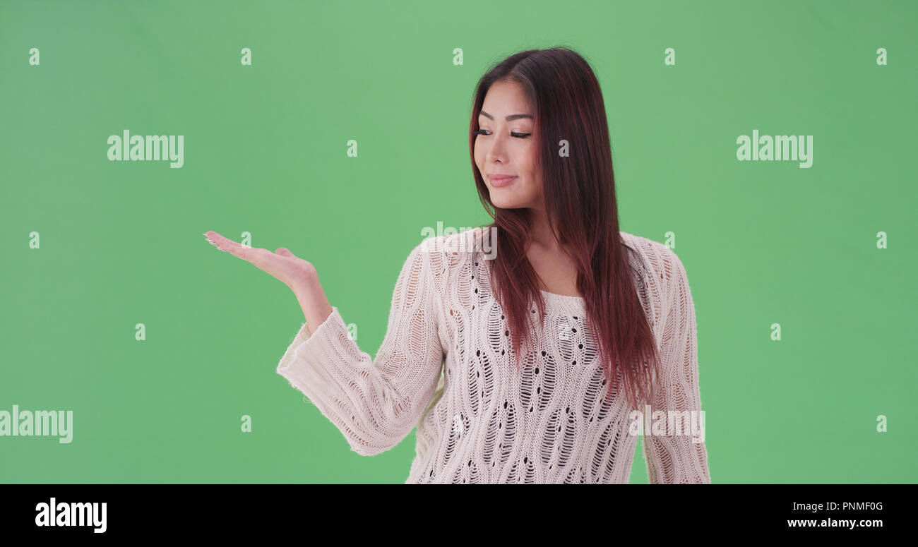Beautiful Asian woman with hand out on green screen Stock Photo - Alamy