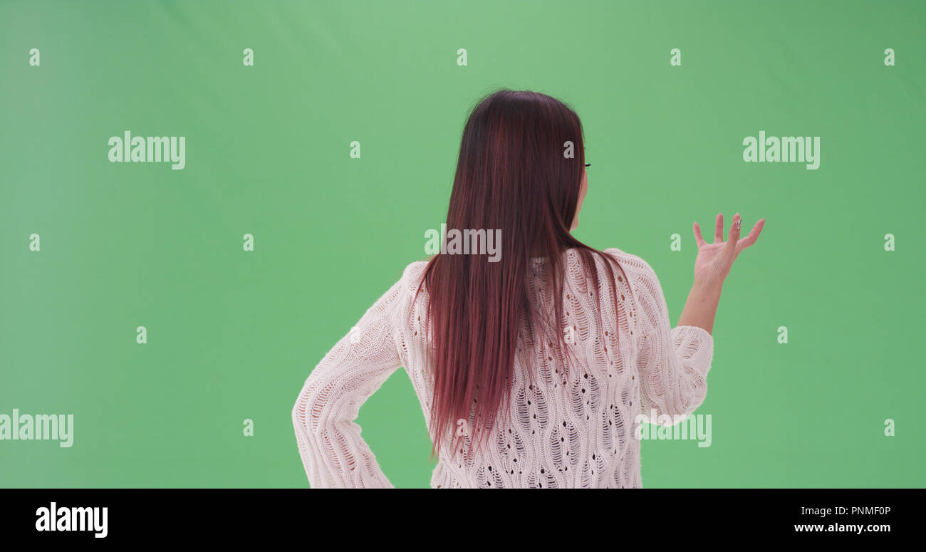 Asian woman standing holding imaginary object on green screen Stock ...