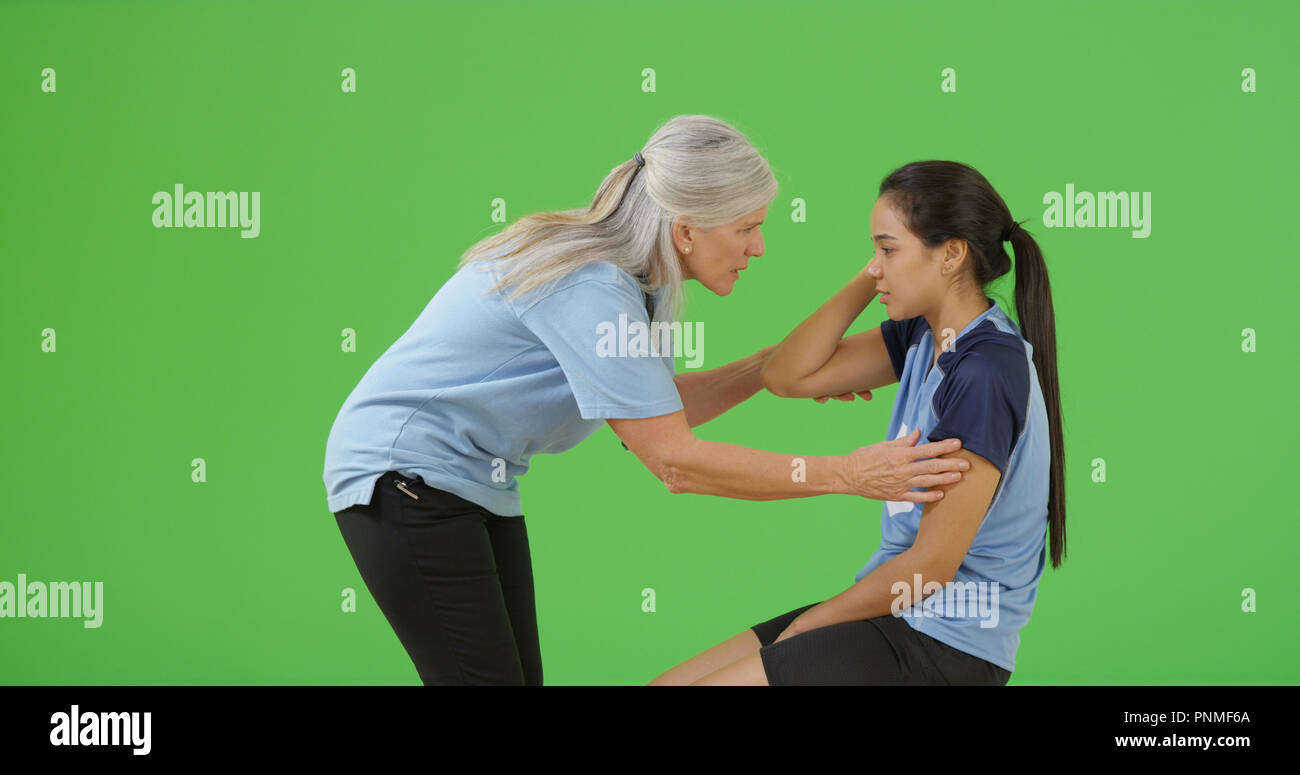 Soccer referee checks that the injured player is not concussed on green ...