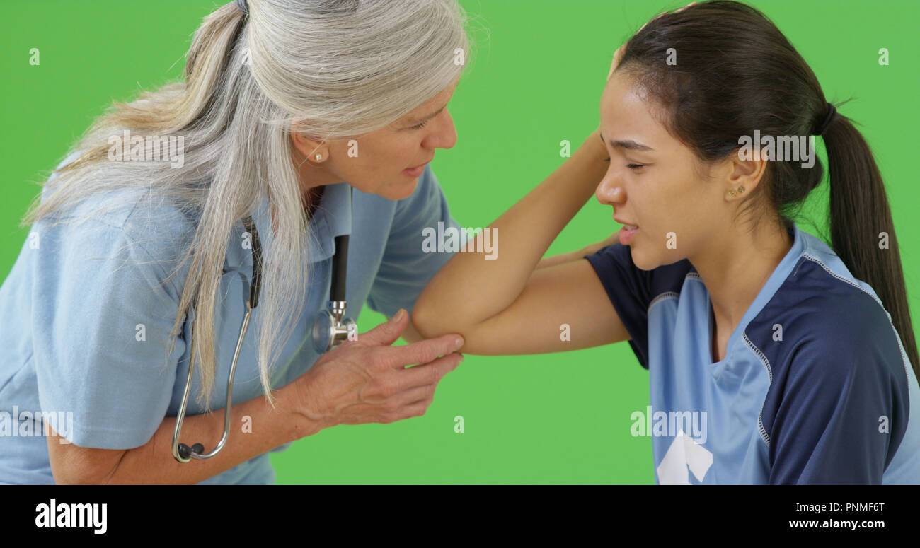 A medical professional attends to an injured soccer player on green ...