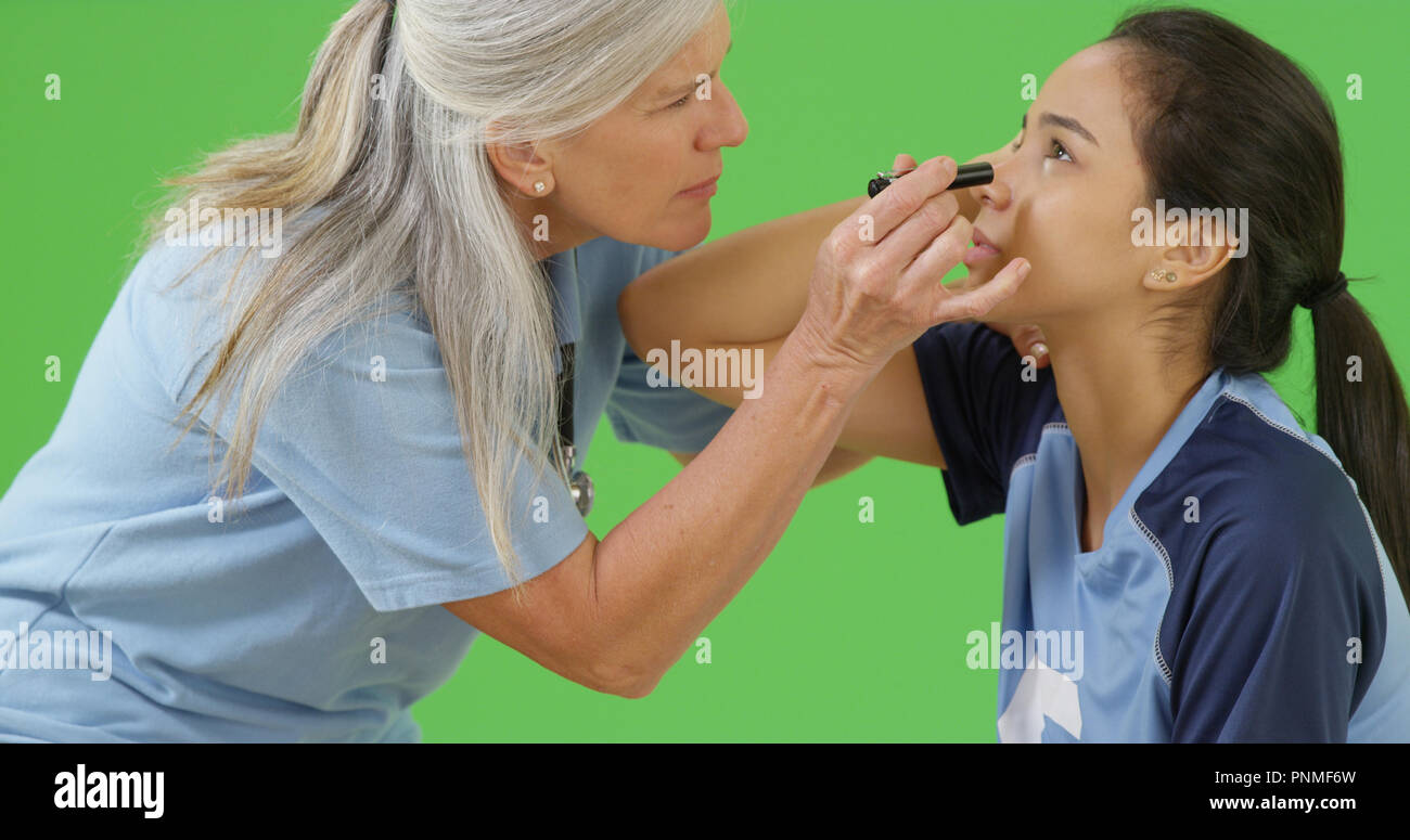 A medical professional attends to an injured soccer player on green ...