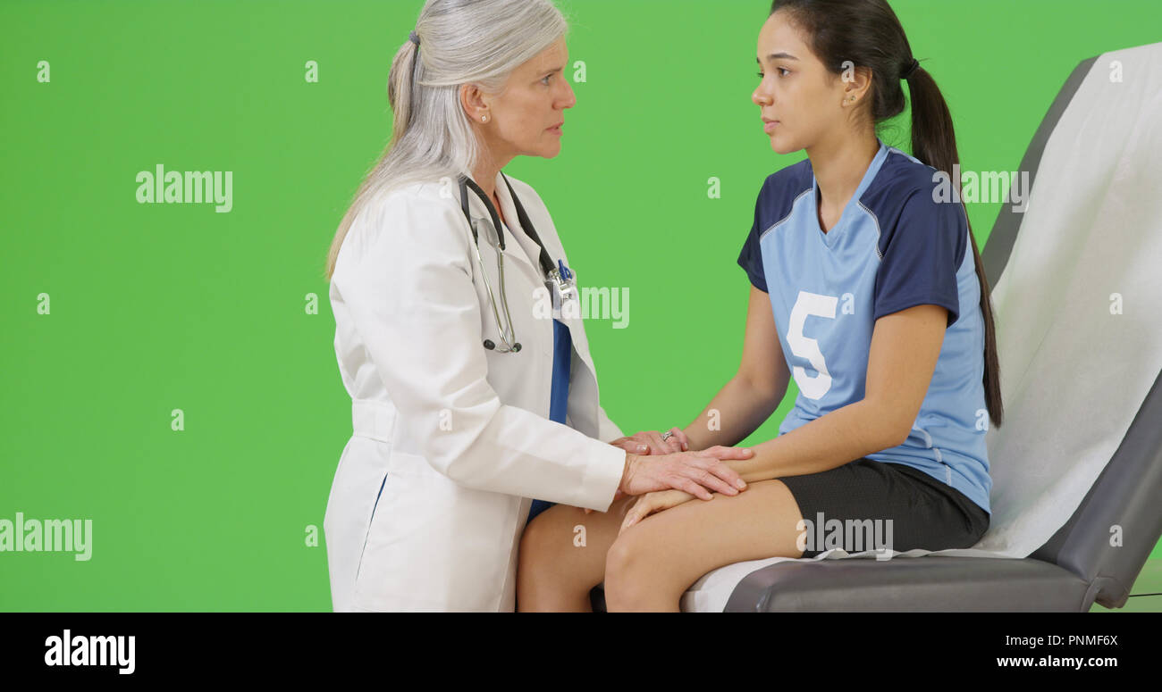 An injured soccer player seeks medical attention on green screen Stock ...