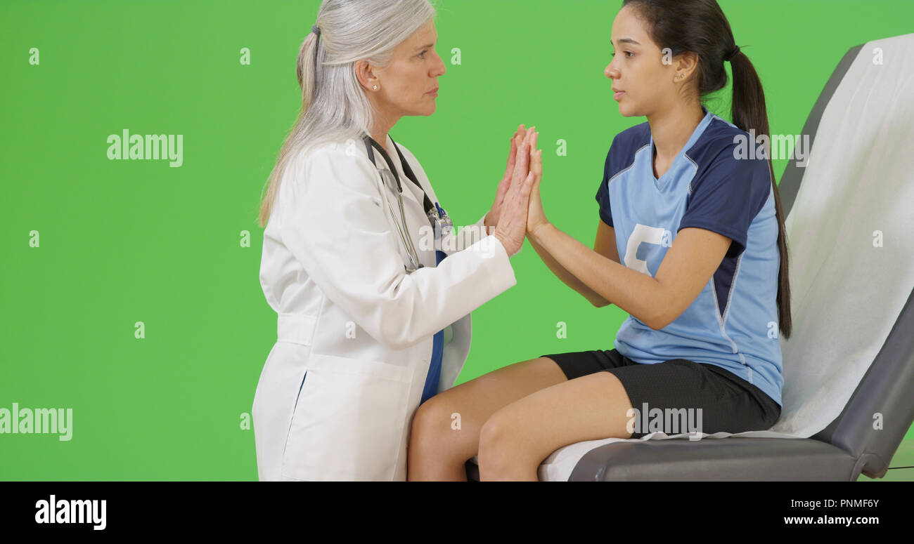 An injured soccer player seeks medical attention on green screen Stock ...