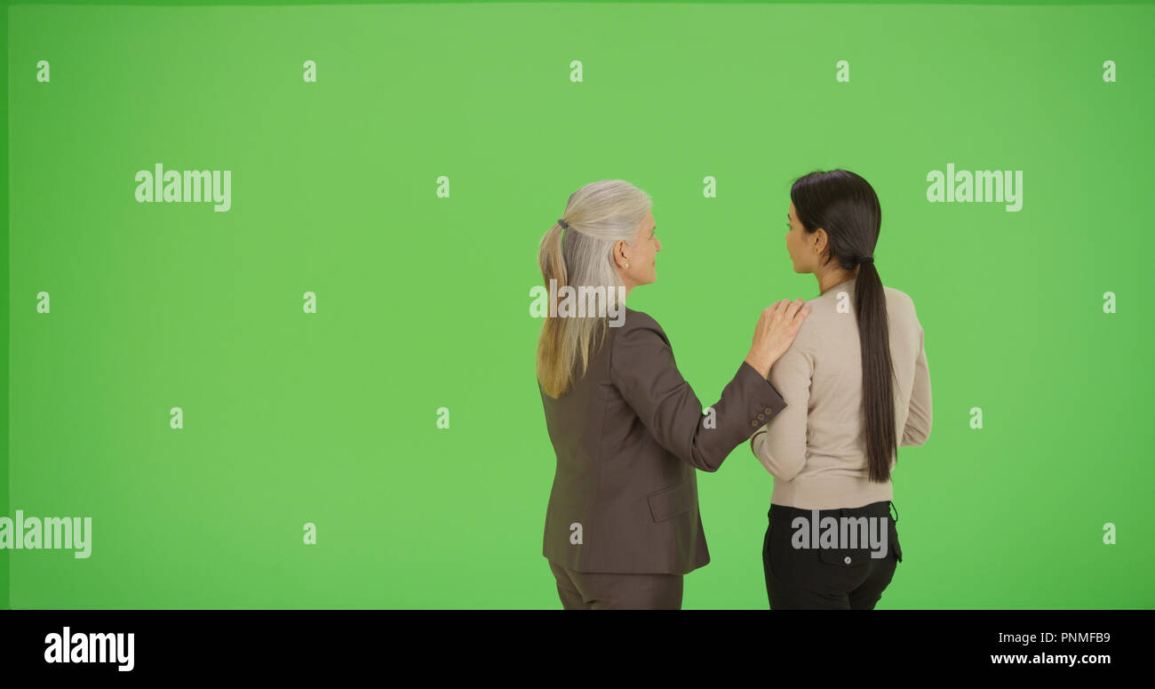 Corporate boss advises young employee on green screen Stock Photo - Alamy