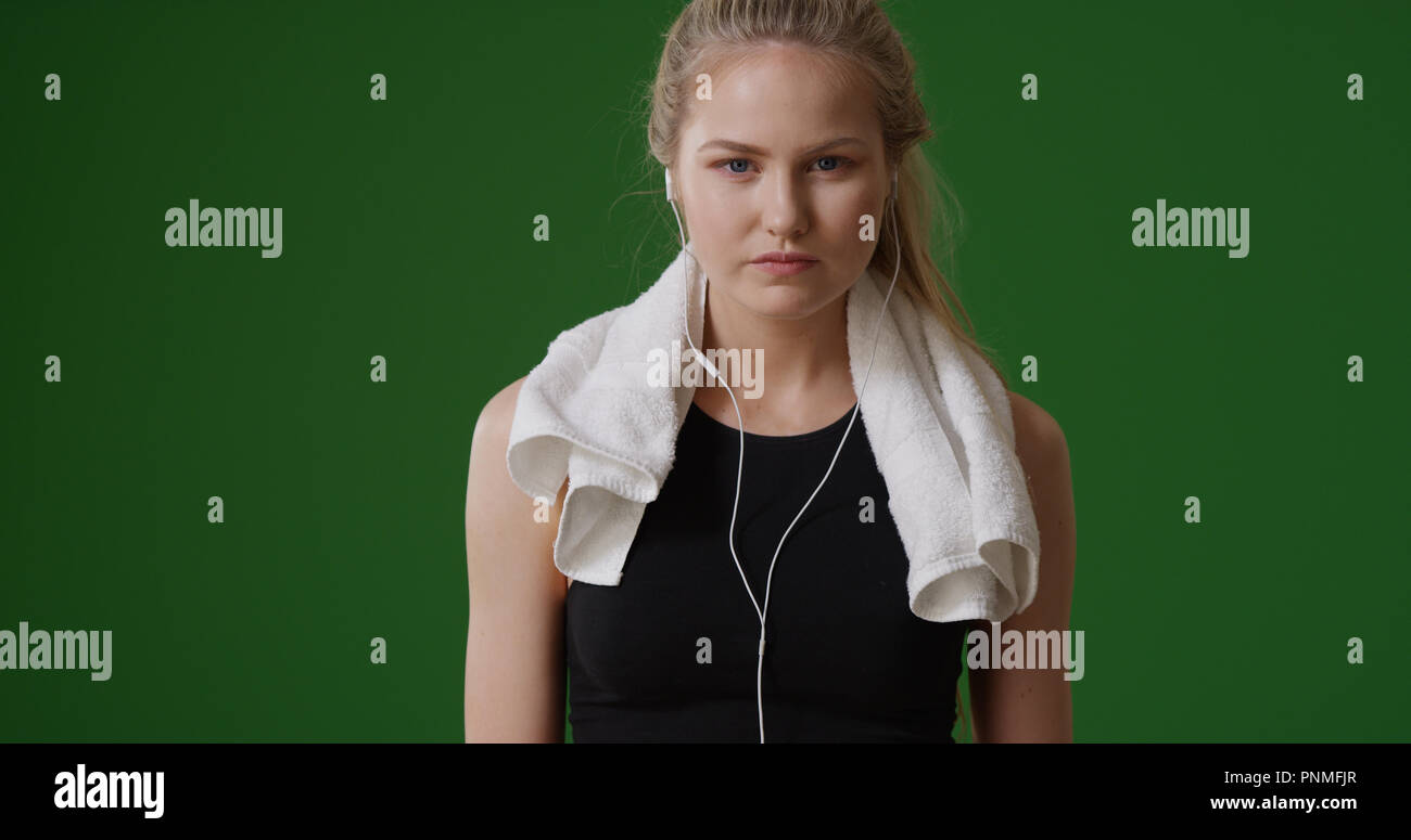 Fit Caucasian girl in sportswear looking at camera on green screen ...