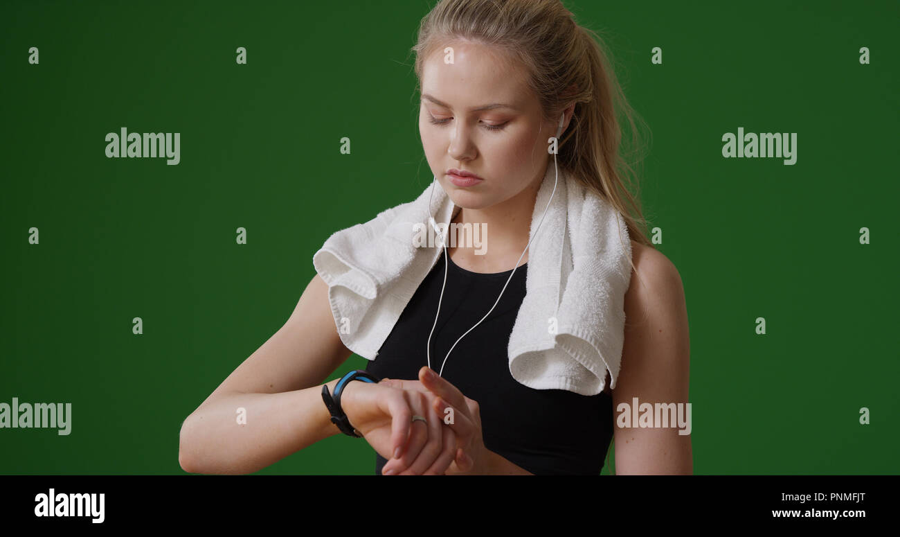 Athletic Caucasian woman setting timer on watch on green screen Stock ...