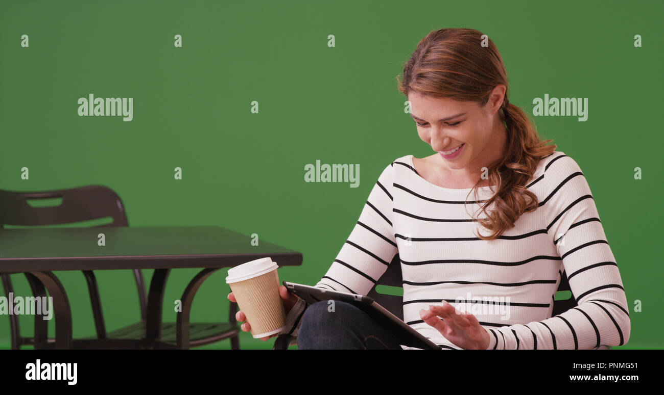 Beautiful girl watching video on tablet at cafe on green screen Stock ...
