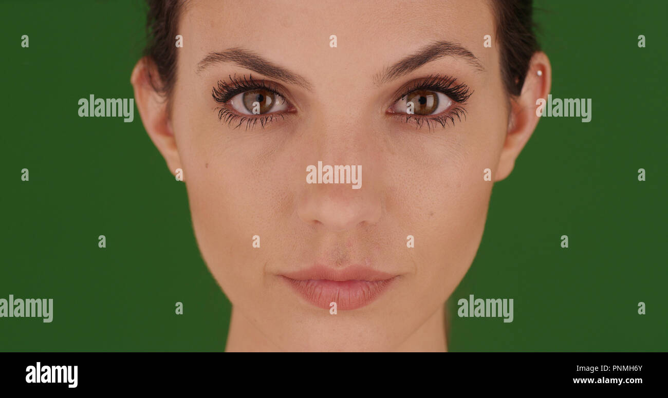 Frontal shot of beautiful young white woman's face on green screen ...