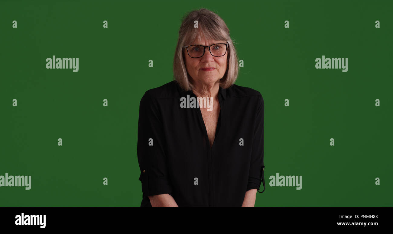Somber looking old Caucasian woman sitting on green screen Stock Photo ...