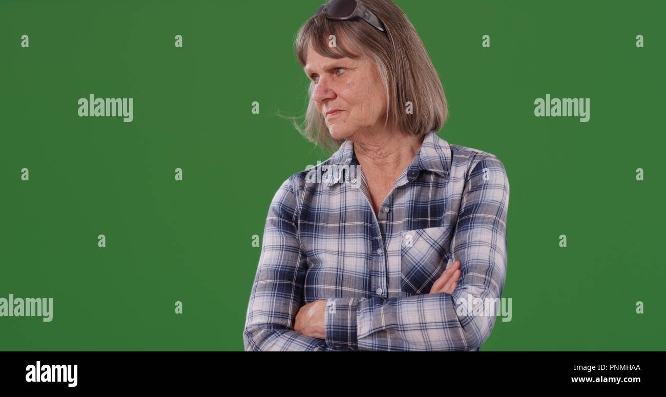 Serious White Senior Woman Crossing Arms Standing On Green Screen Stock