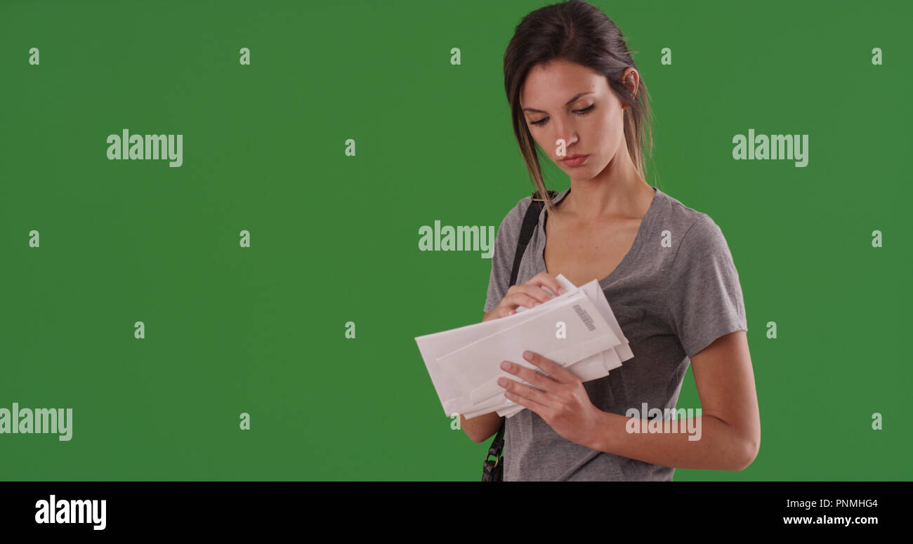Caucasian woman looking through letters she received in the mail on ...