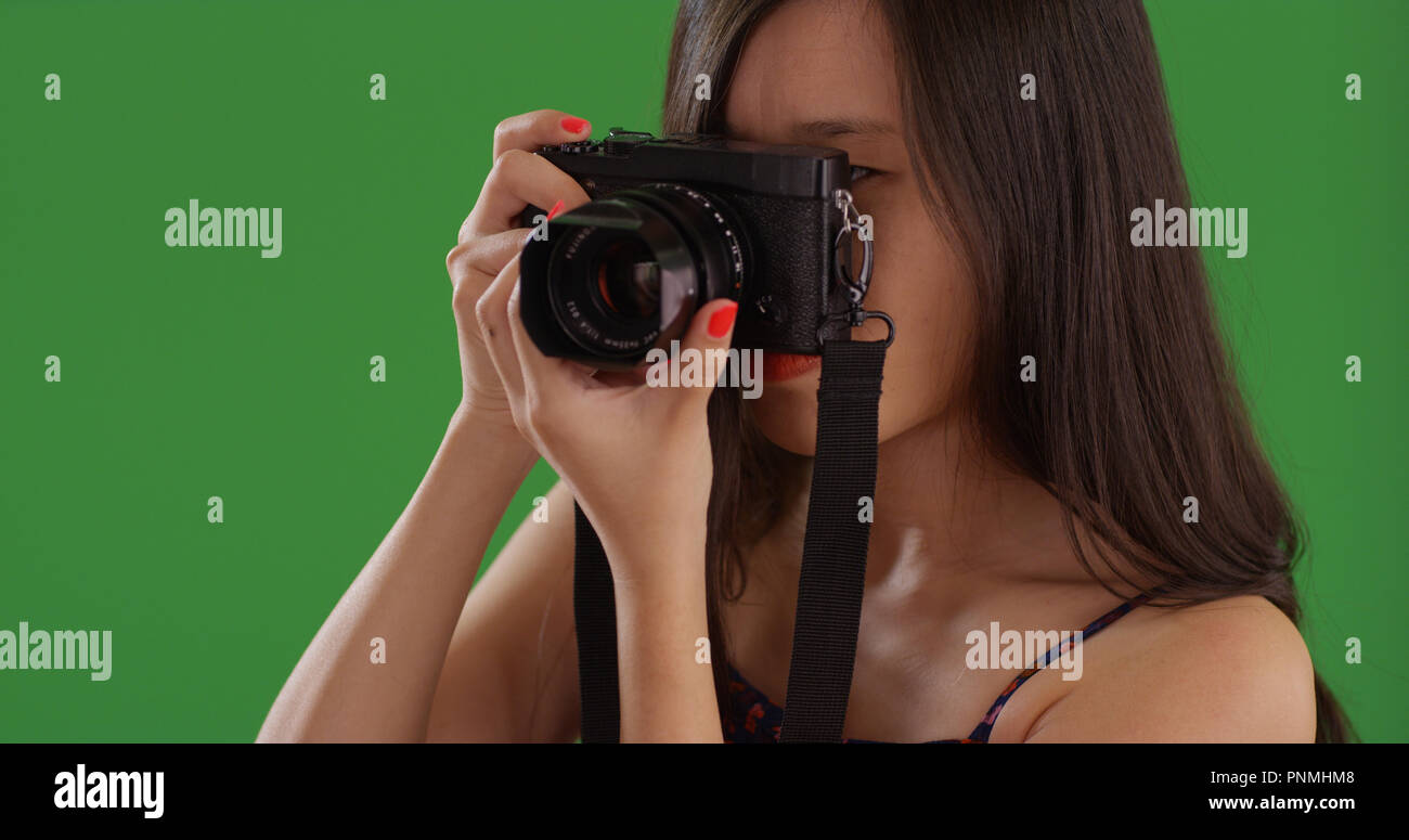 Asian female taking snapshot using digital camera of green screen Stock ...