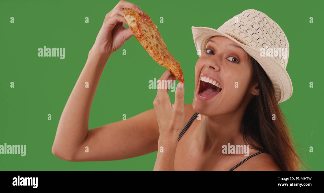 Happy young woman holding cheesy pizza slice and smiling on greenscreen ...