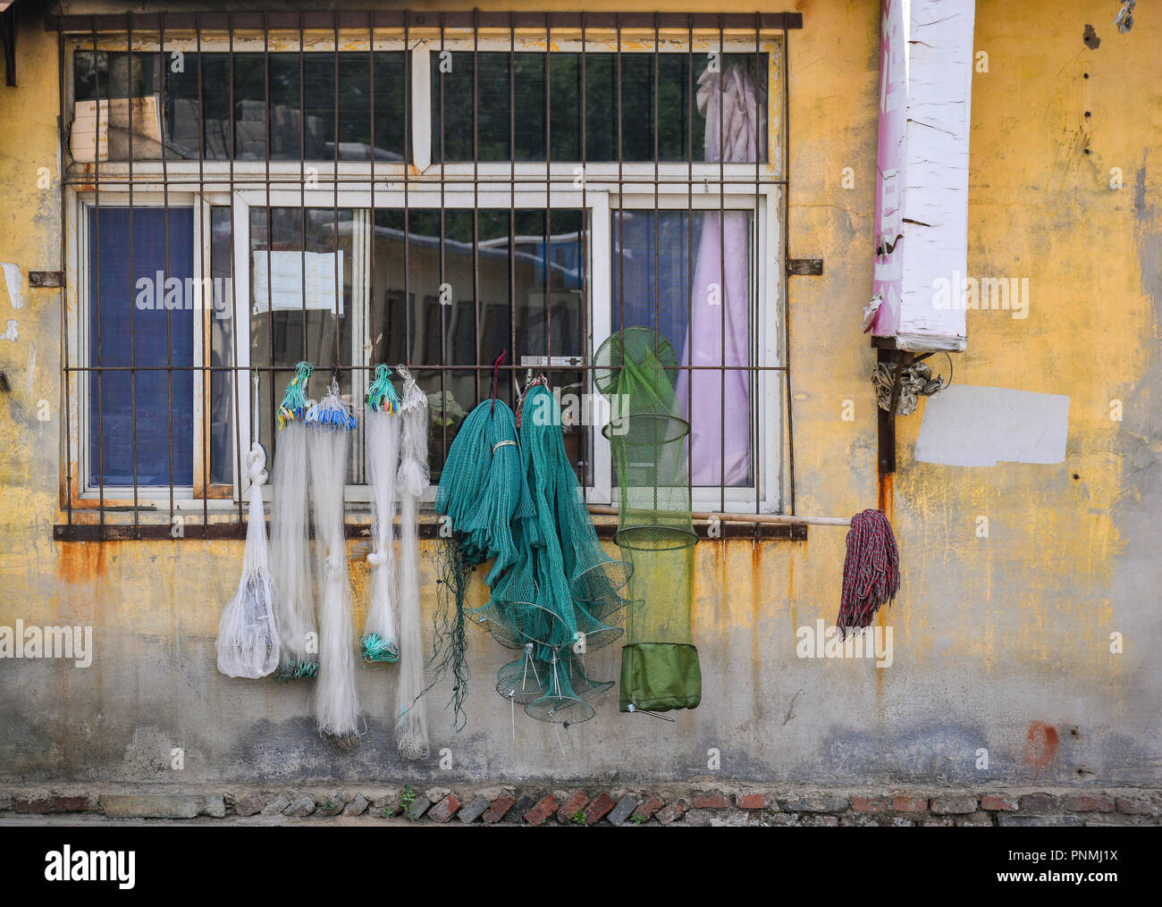 A window with many fish nets drying outside Stock Photo - Alamy
