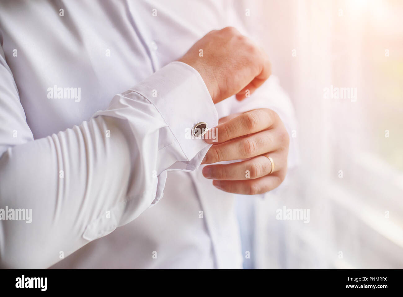 Man adjusting cufflinks hi-res stock photography and images - Alamy