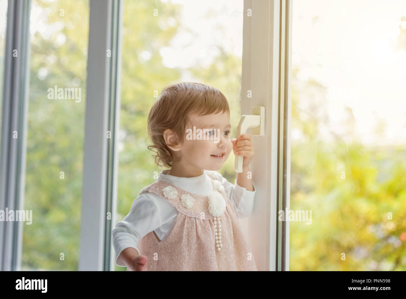 Little cute sweet smiling girl in pastel pink dress standing on the ...