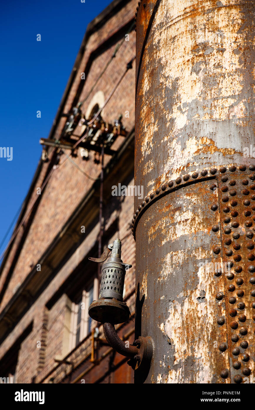 Rusty industrial chimney with brick warehouse Stock Photo - Alamy