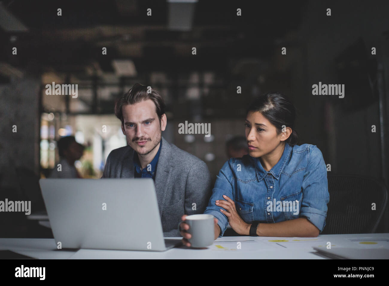 Coworkers working late in the office Stock Photo - Alamy