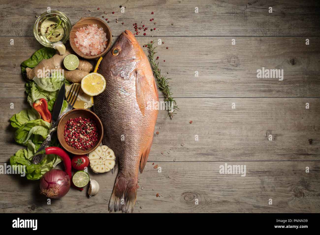 Fresh raw red snapper fish with spices, herbs and vegetables for ...