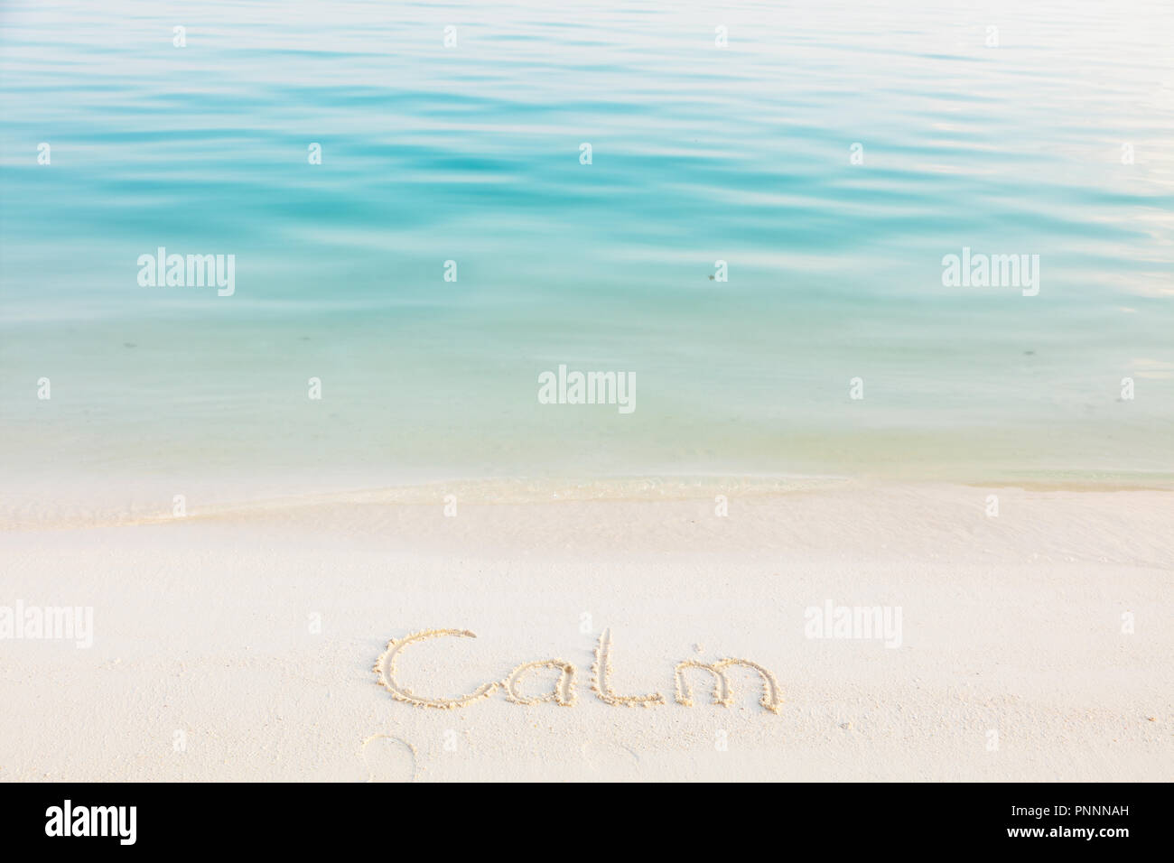 The Word Calm Written in the Sand on a Beach with blue sea background ...