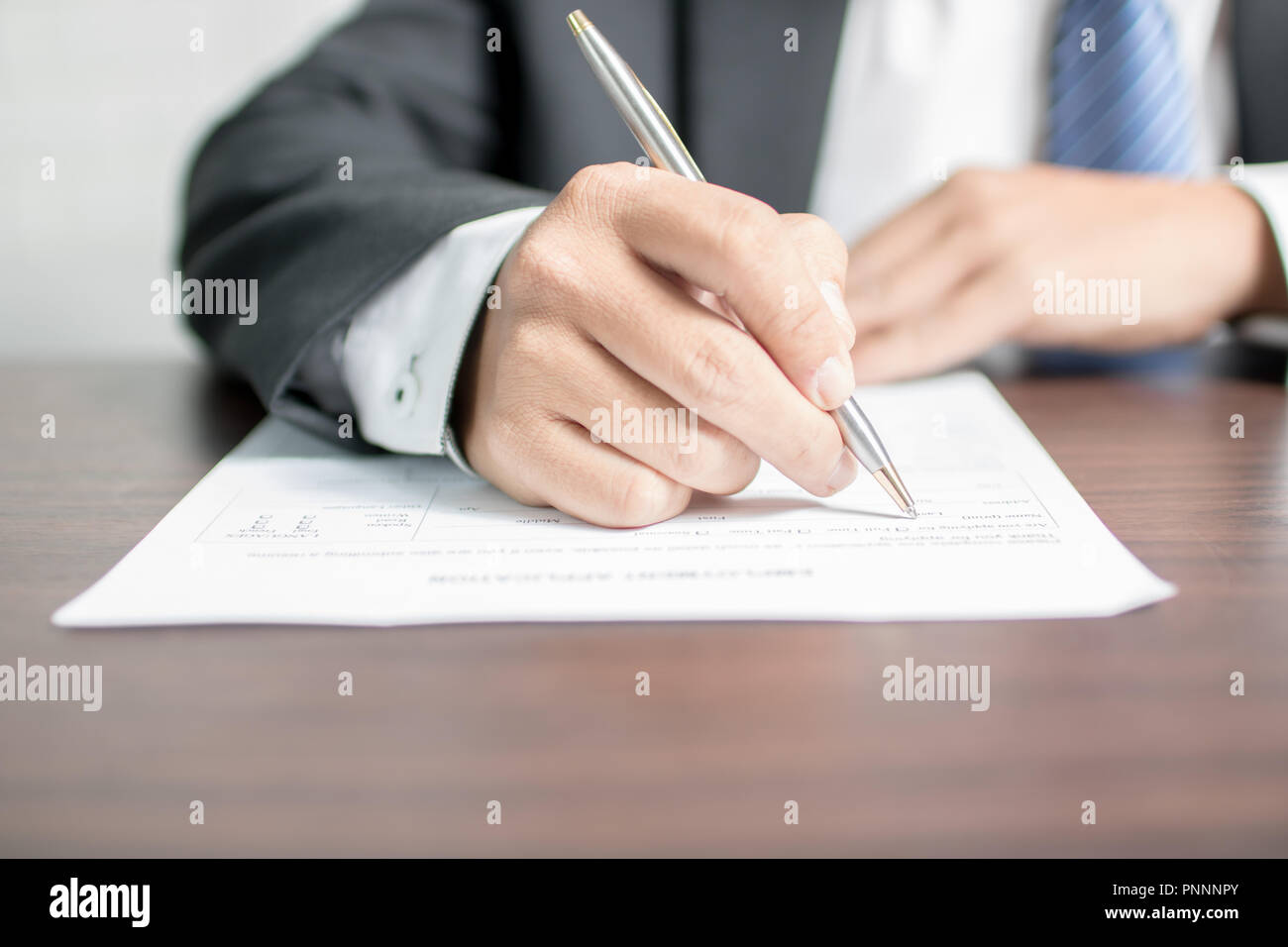 businessman writing on application form Stock Photo - Alamy
