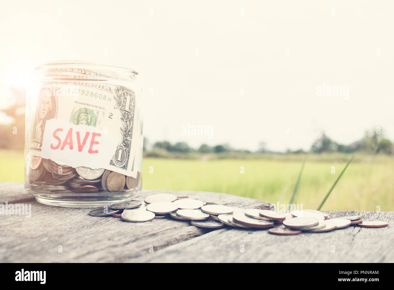 Full of money coins and banknote in glass jar on table, save concept ...