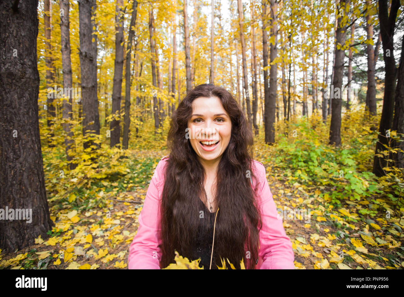 Autumn, fun and people concept - Young beautiful woman in pink jacket ...