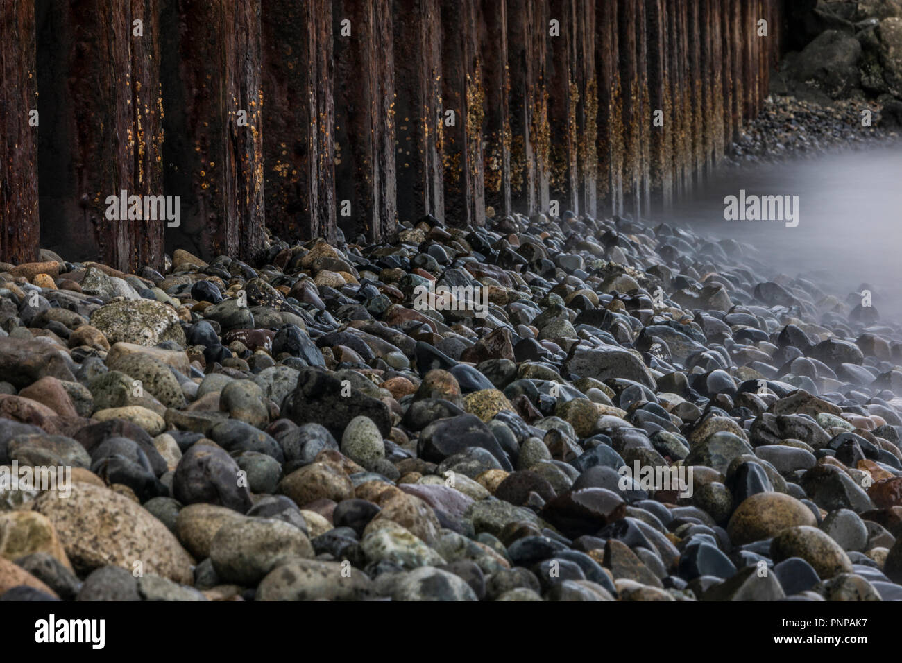Wet rocks and rusty pillars with mist of water Stock Photo - Alamy