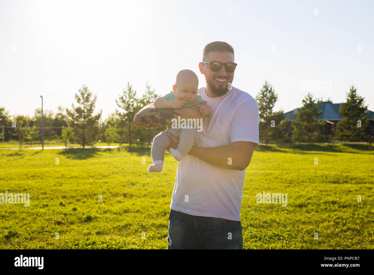 Happy father holding baby son on nature. Concept of happy family ...