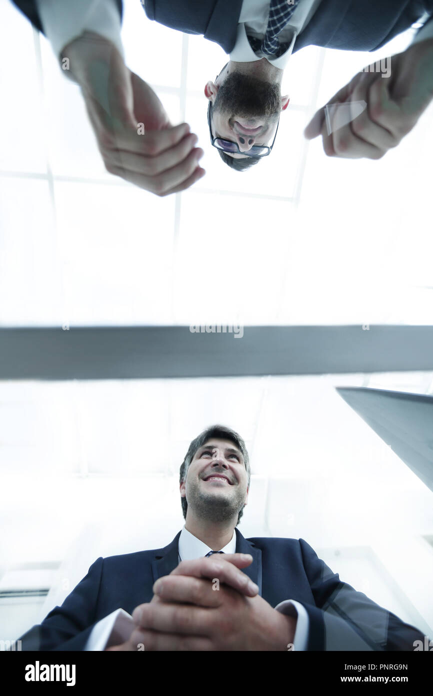 View from below. From behind the glass. Two businessmen sitting at the ...
