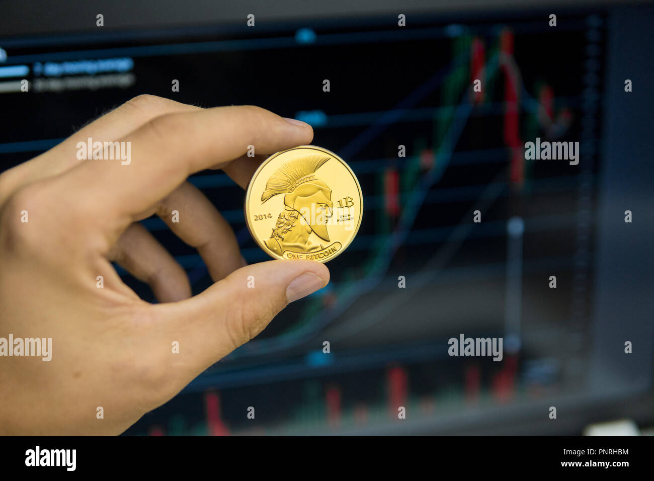 Male businessman hand holding titan bitcoin on a background of growth ...