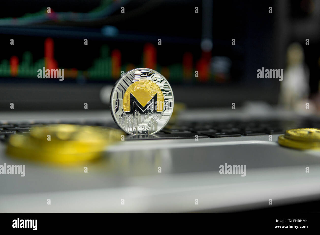 Golden Monero coin with gold coins lying around on a black keyboard of ...