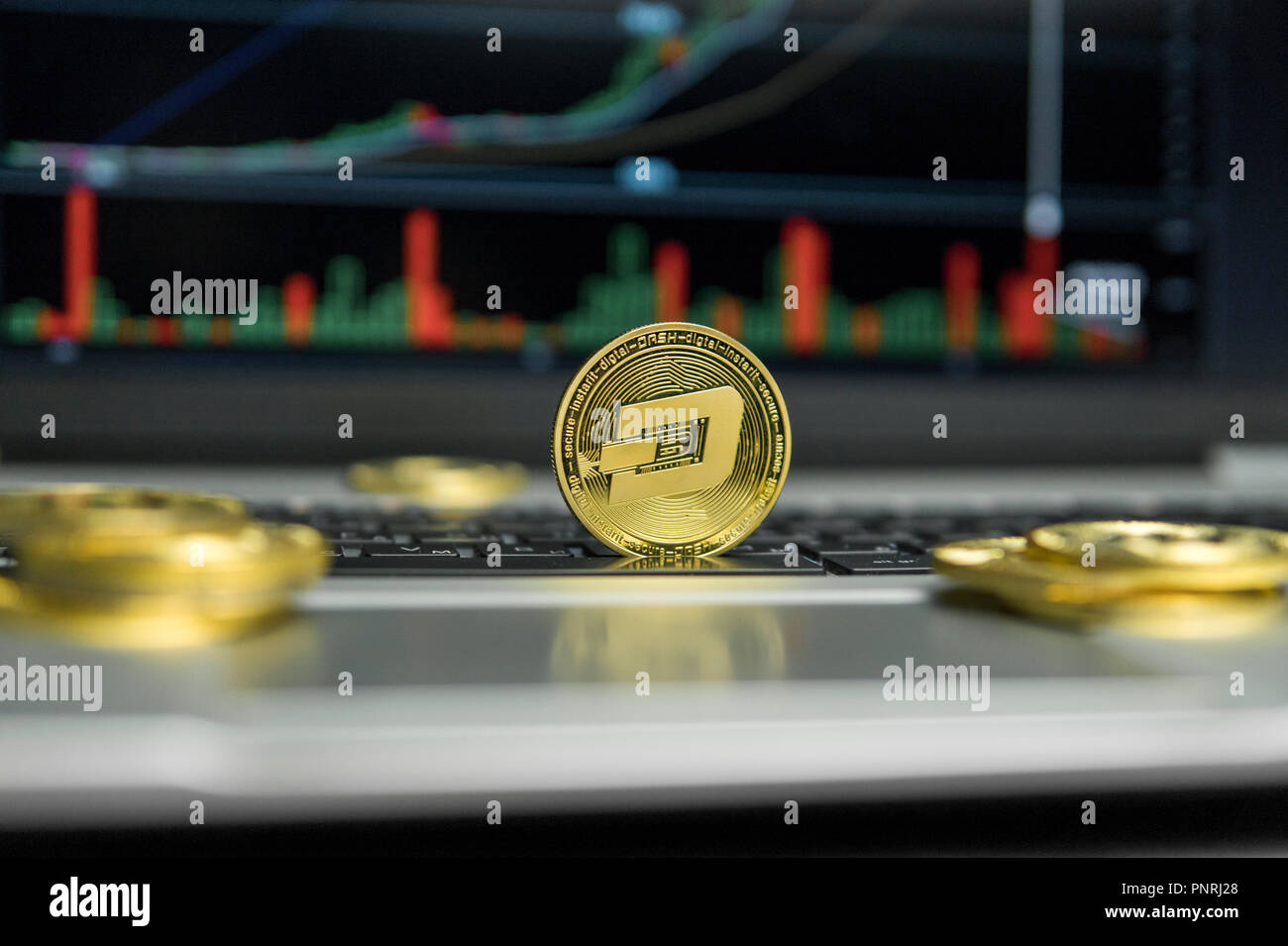 Golden Dash coin with gold coins lying around on a black keyboard of ...