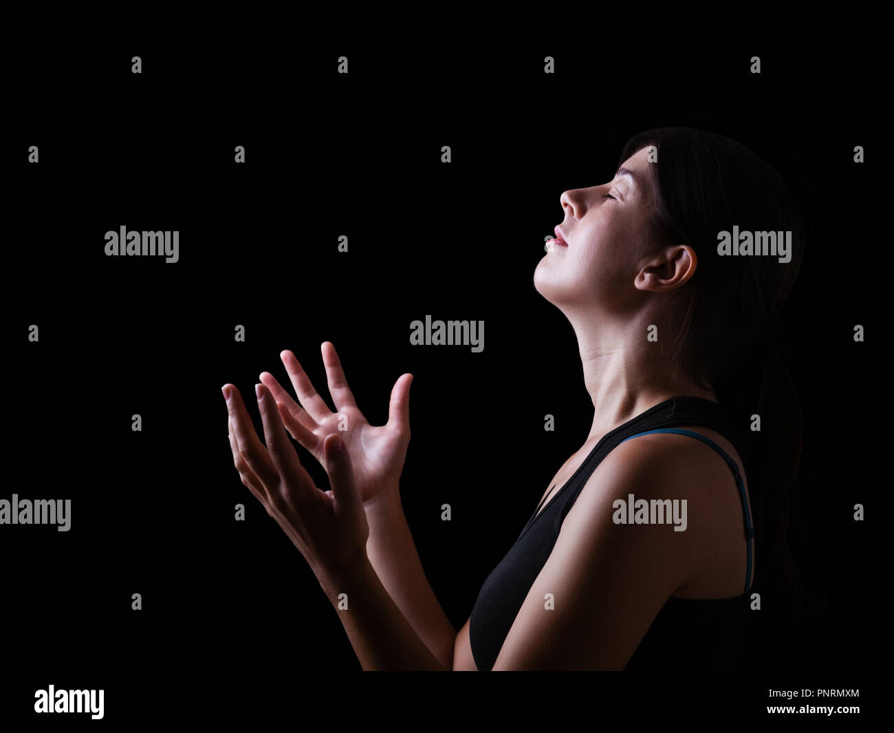 Low key of a faithful woman praying and feeling the presence or being ...