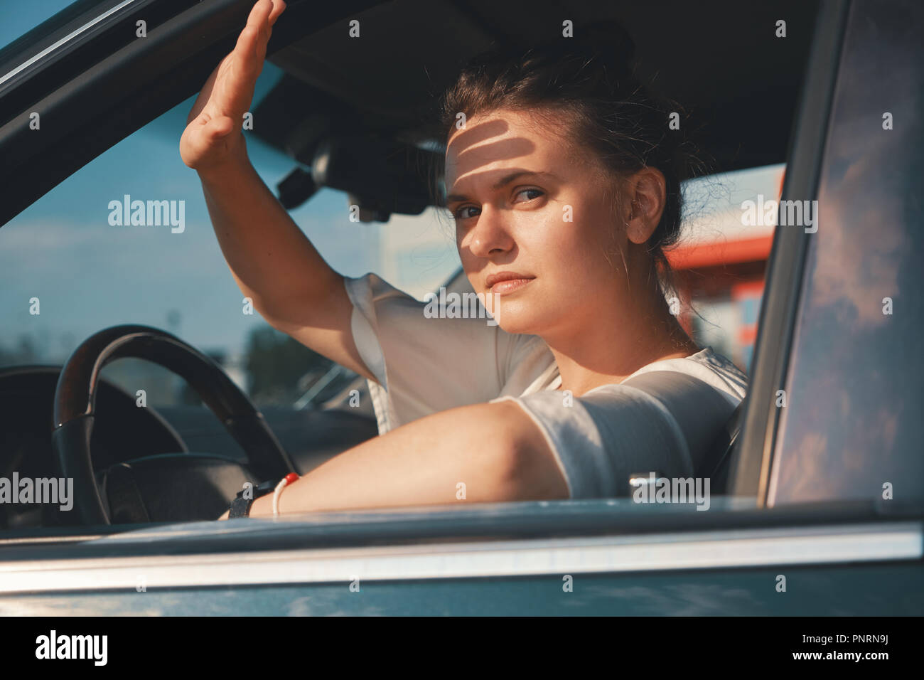View of attractive young woman in casual wear put head out of window ...