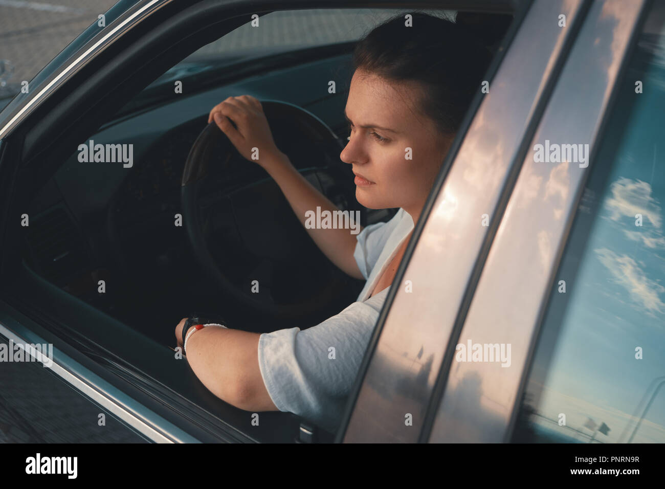 View of attractive young woman in casual wear put head out of window ...