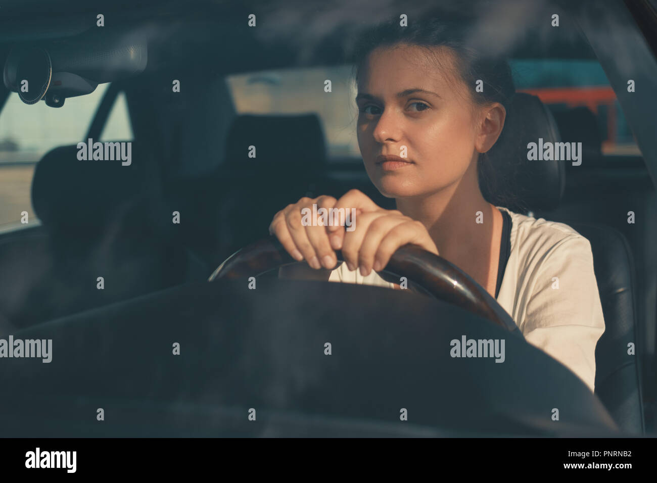 Young business woman driving car - looking through front window. Close ...