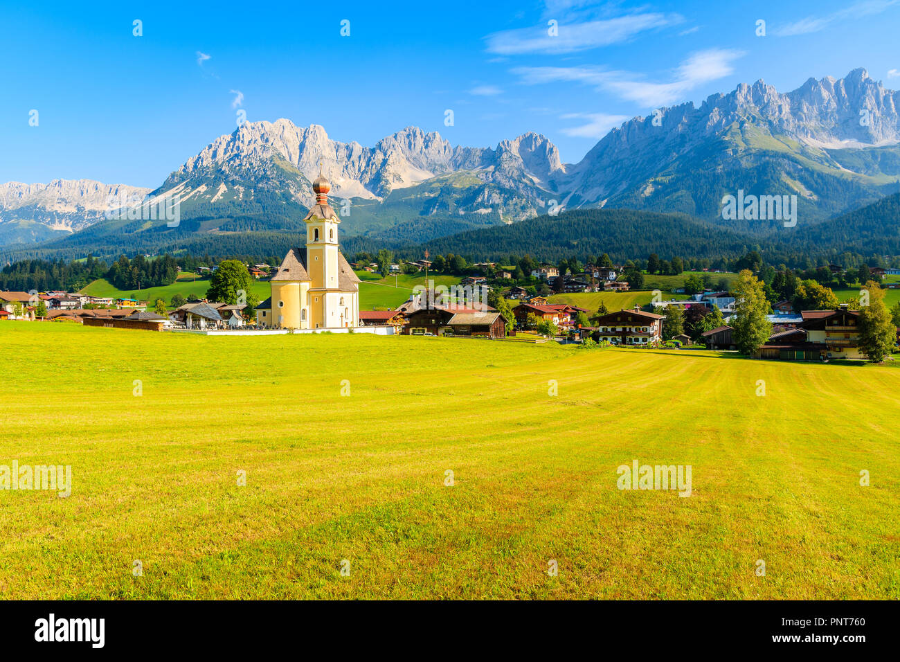 View of church in Going am Wilden Kaiser mountain village on sunny ...