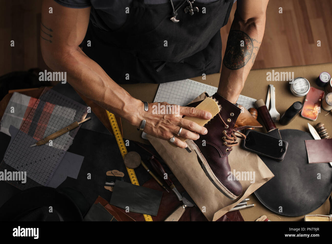 Care for leather shoes, close up of cropped shoemaker hands rubbing up ...